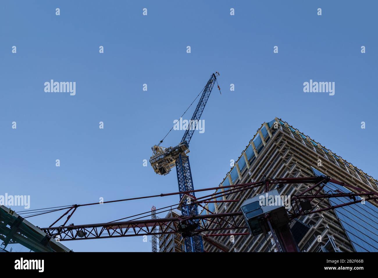 Construction of a skyscraper on blue sky background Stock Photo - Alamy