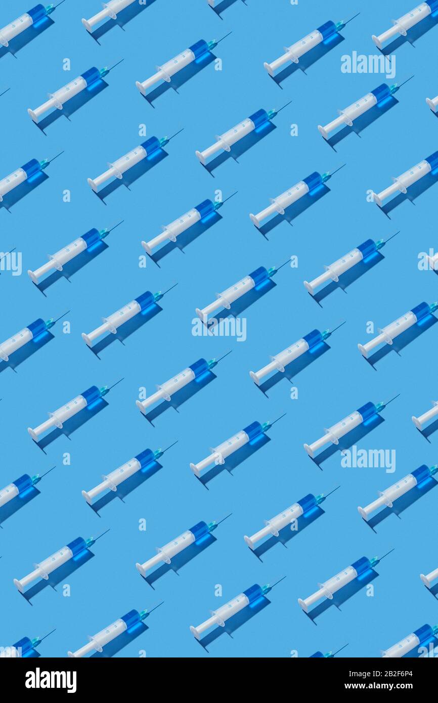 Vertical healthcare pattern from sterile plastic syringes with blue ...