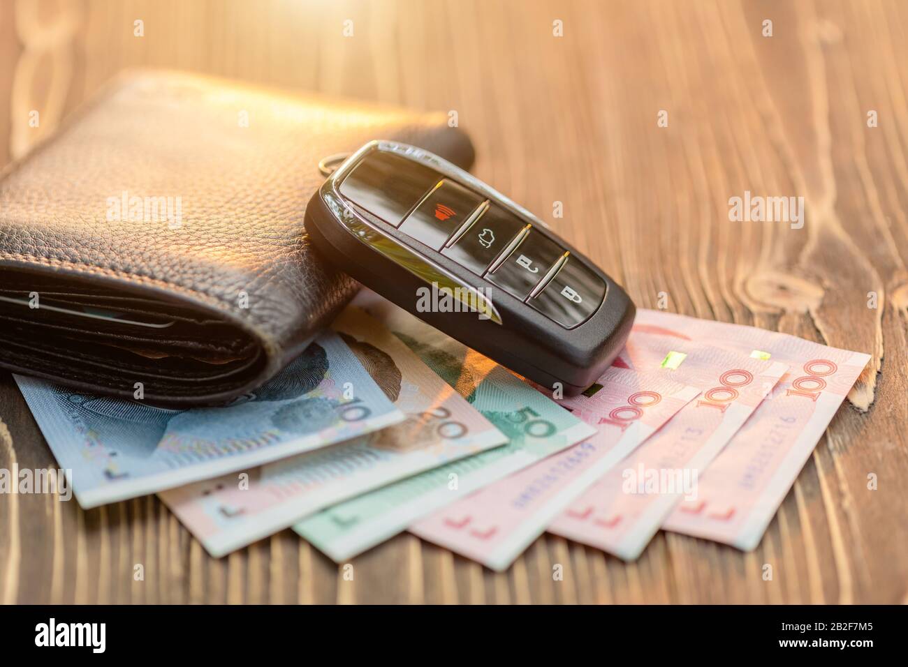 Close up new car keys with Chinese banknote on wooden table. Car ...