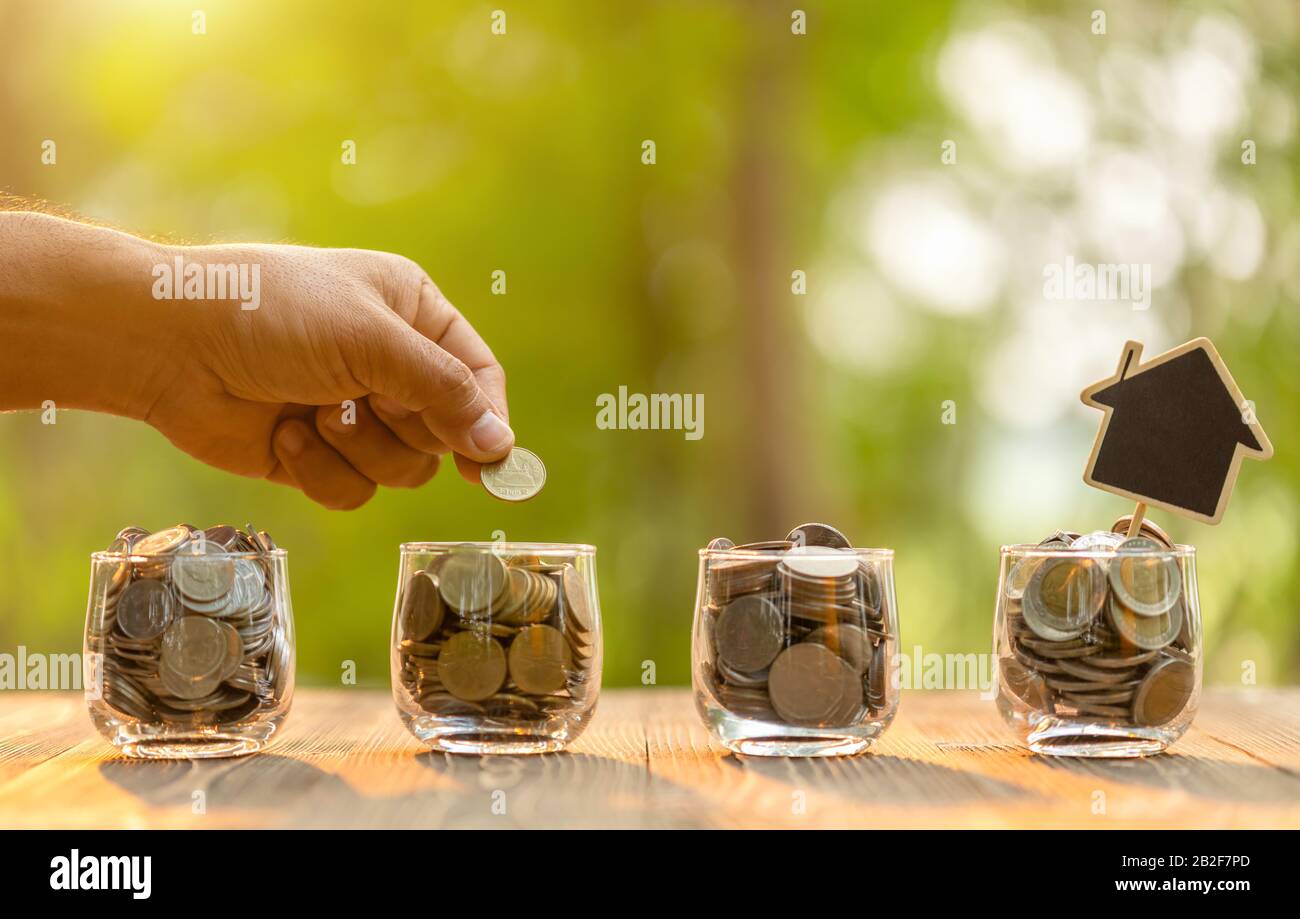 Coin jar house savings hand hi-res stock photography and images - Alamy