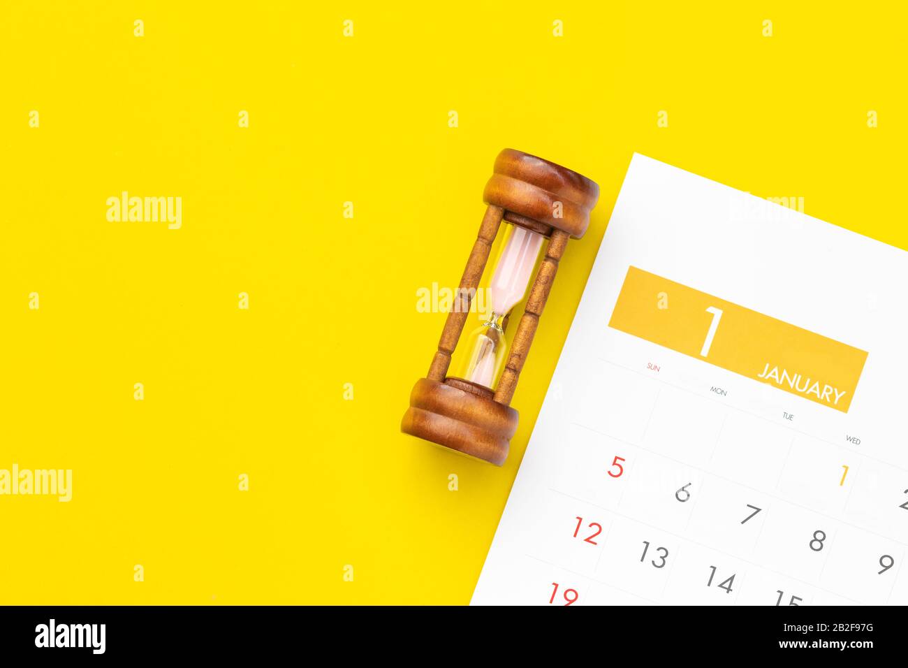 Close up vintage hourglass or sandglass on new year calendar for ...