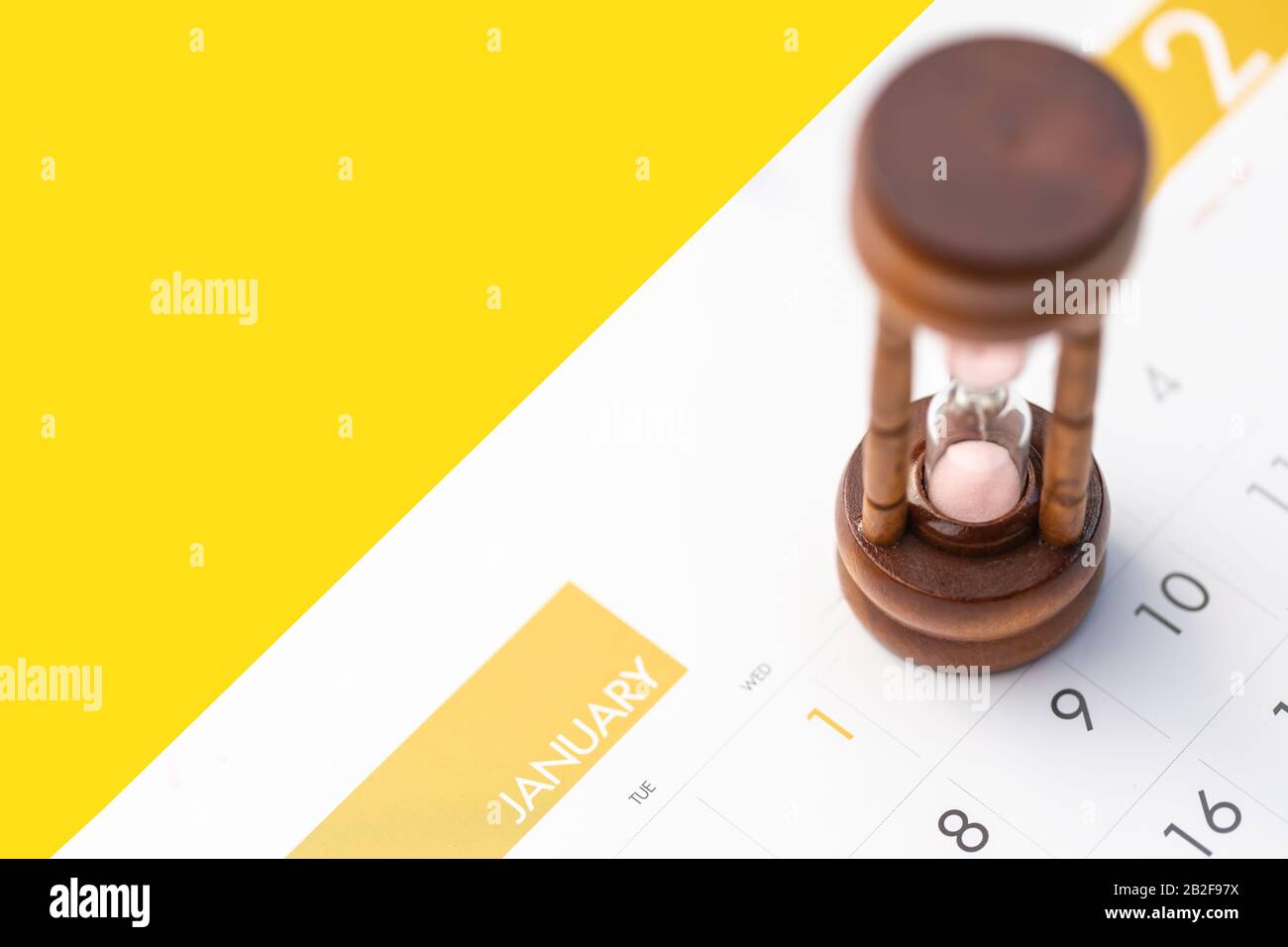 Close up vintage hourglass or sandglass on new year calendar for ...