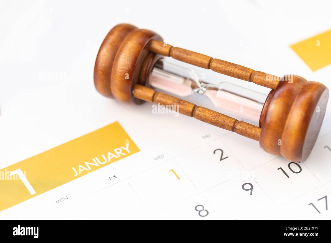 Close up vintage hourglass or sandglass on new year calendar for ...