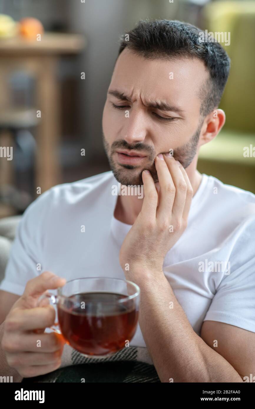 Dark-haired young man suffering from the toothache Stock Photo - Alamy