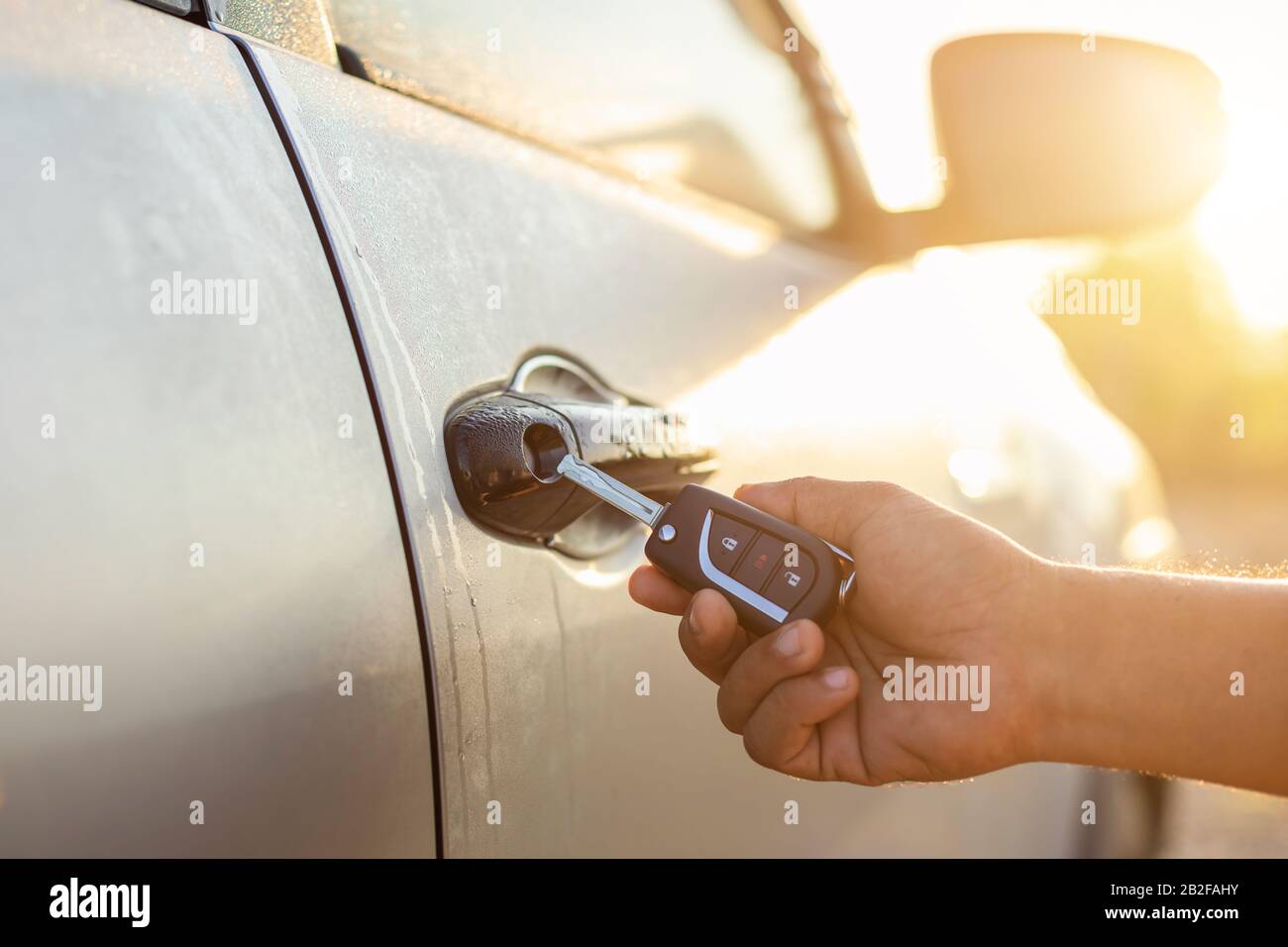 Open the car concept : Hand holding remote car keys and press the ...