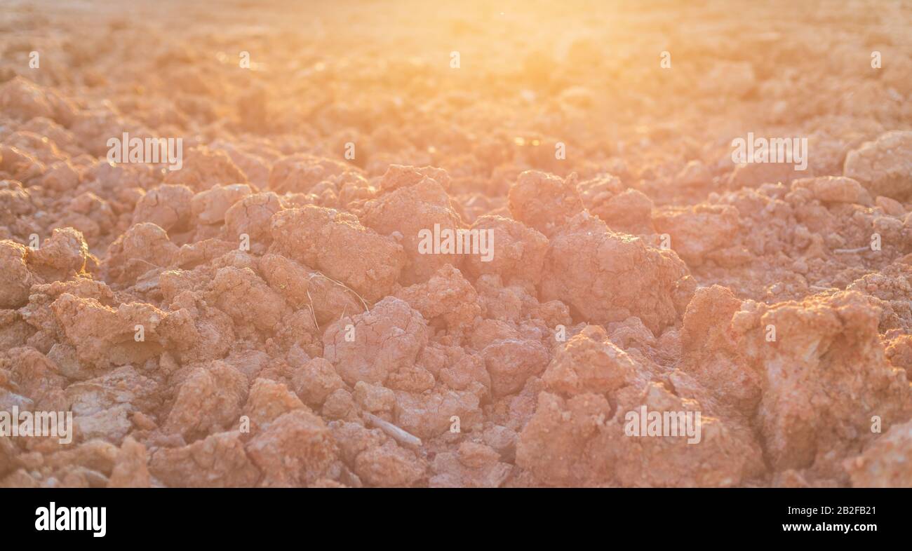 Heap of dry soil and rough mud in construction site. Shoot in sunset ...