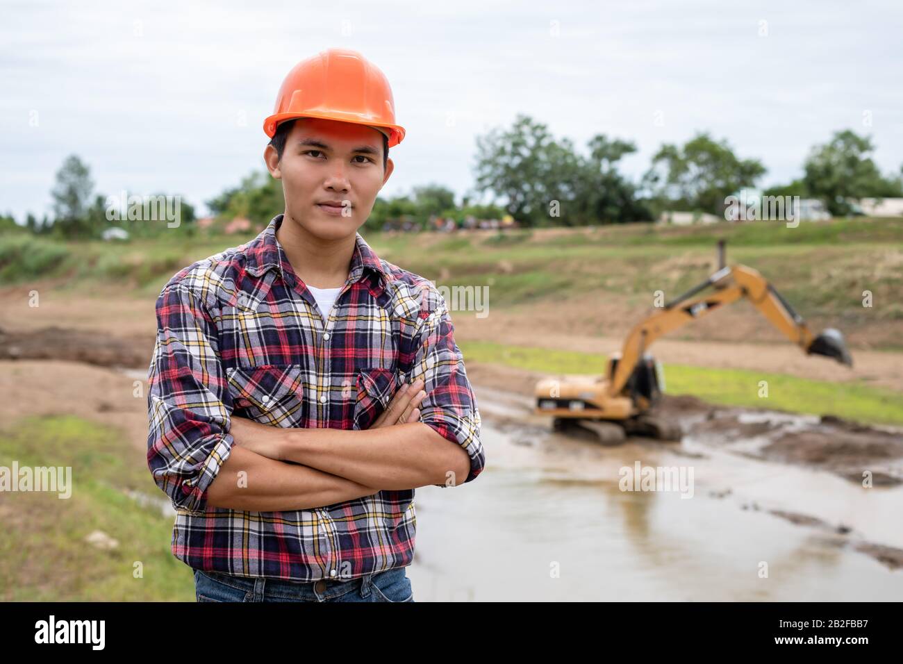 Asian young engineer working on site at the dam and control while ...