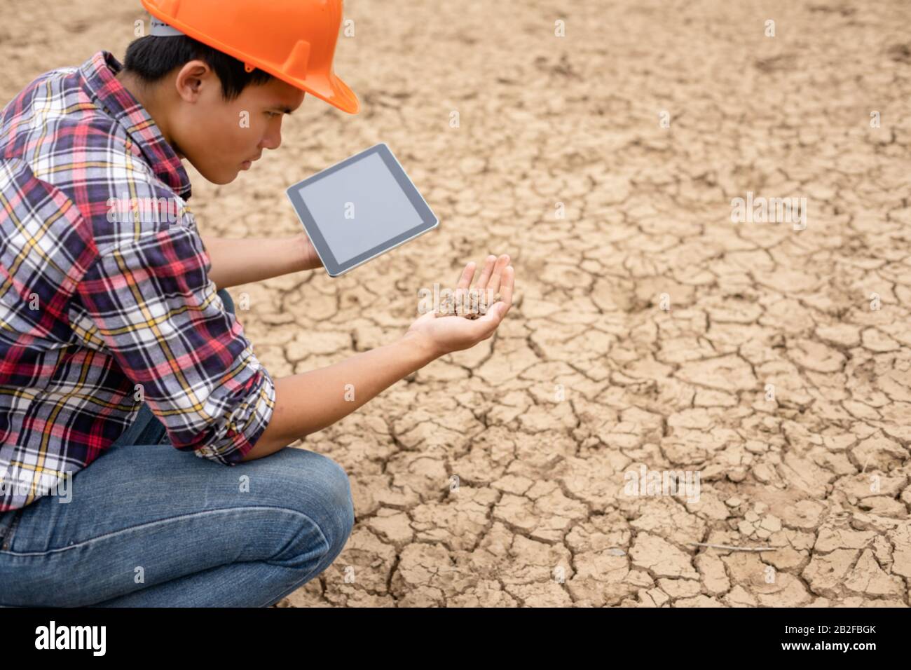 Asian young engineer working on site at the dam and checking the soil ...