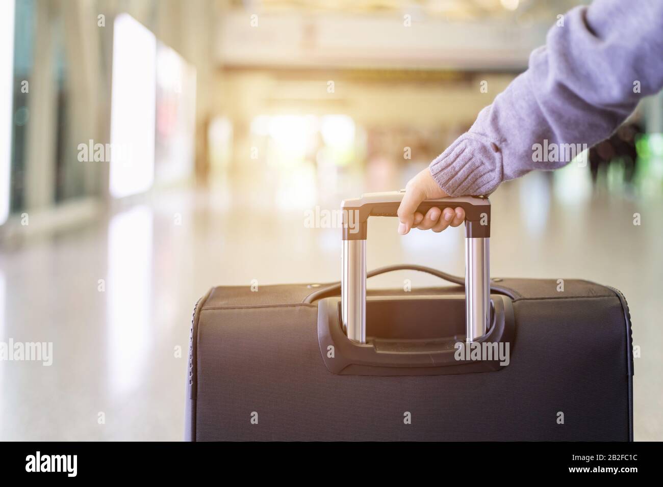 Young tourist walking and pull luggage at the airport. Travel and ...