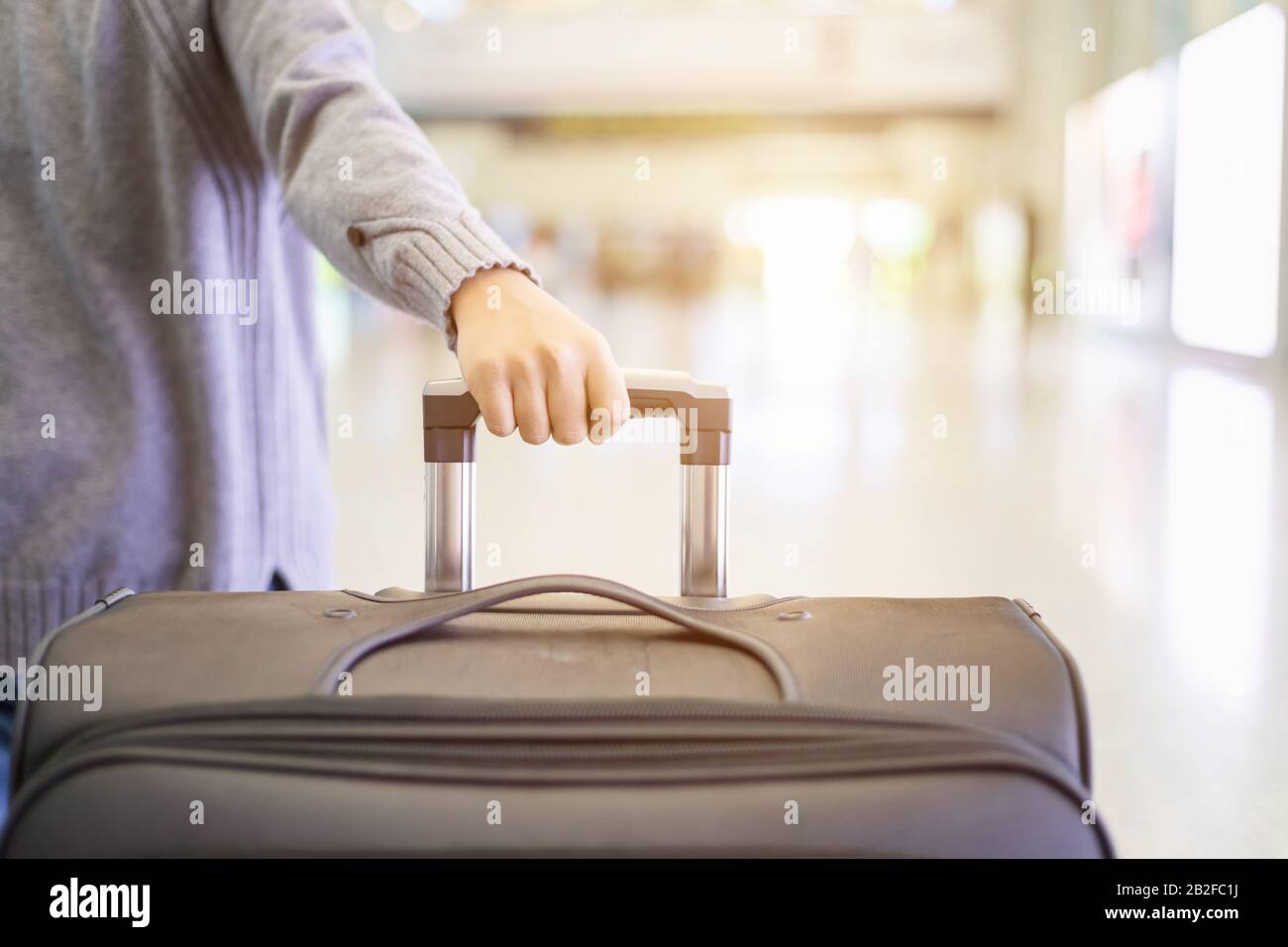Young tourist walking and pull luggage at the airport. Travel and ...