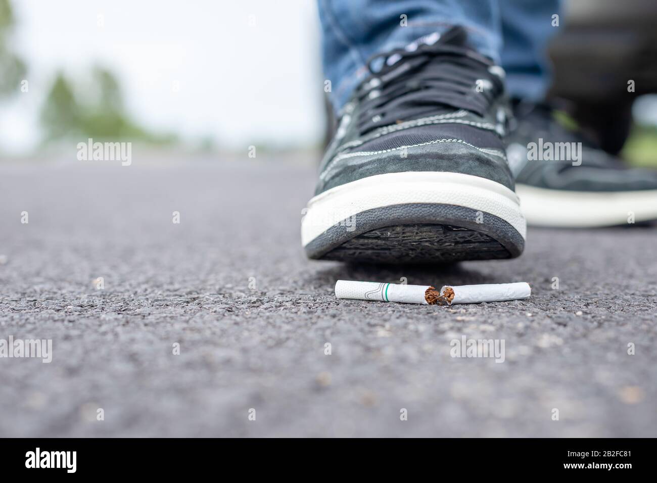 Asian man destroy cigarette by foot. Stop smoking in public area ...