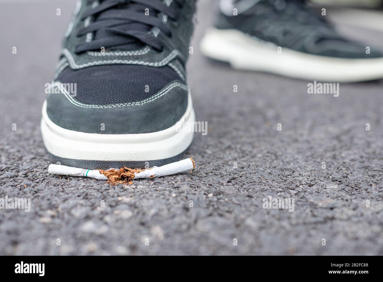 Asian man destroy cigarette by foot. Stop smoking in public area ...