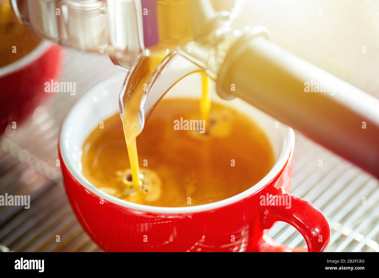 Close up coffee flowing to red cup. Barista making fresh coffee with ...