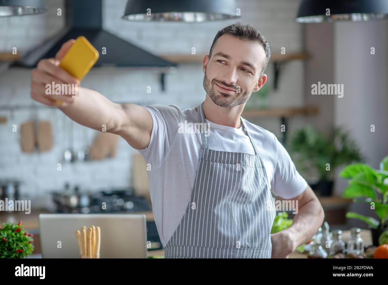 Joyful young man taking a selfie in the kitchen Stock Photo - Alamy