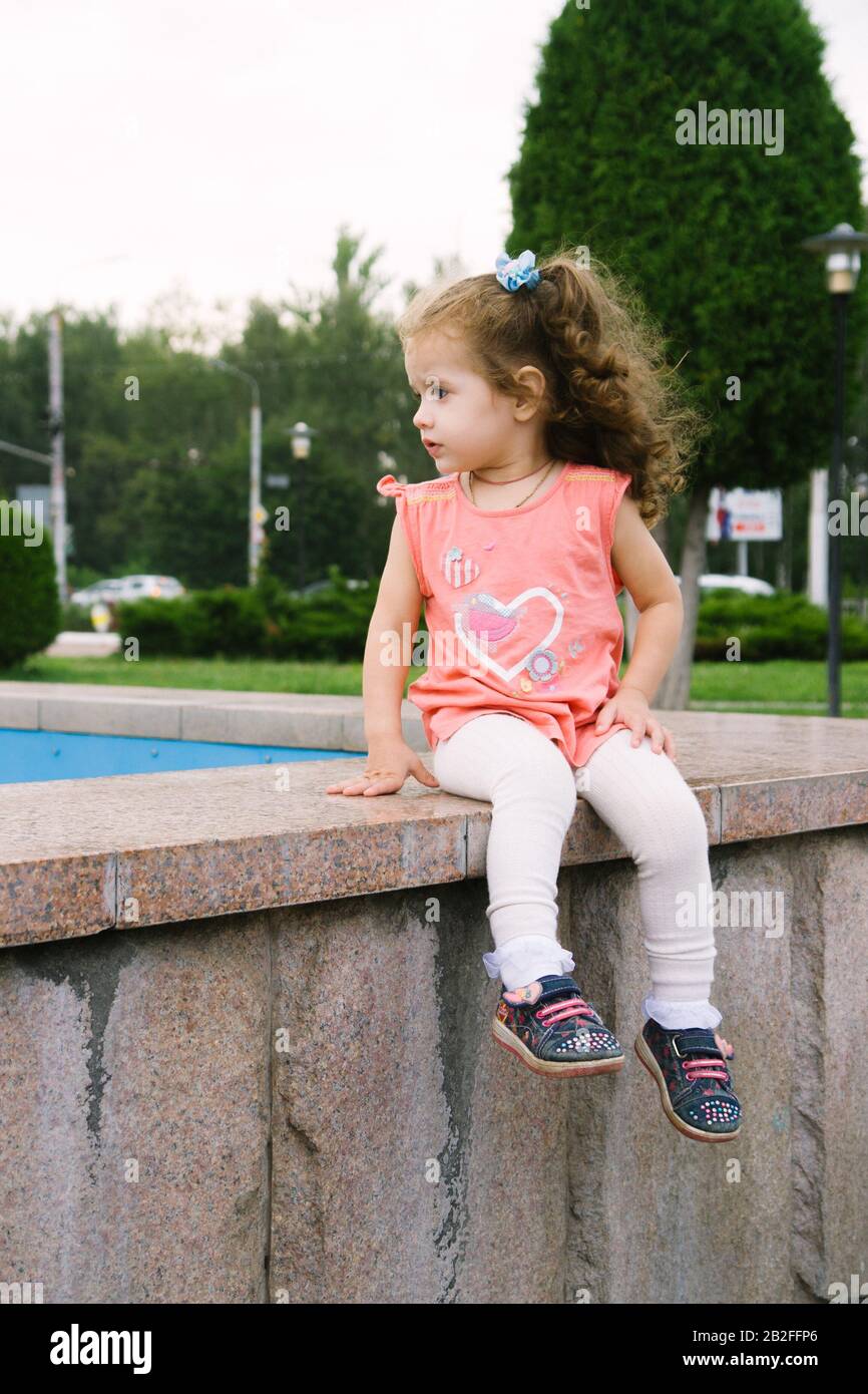 Little baby girl sitting on park, sad Stock Photo - Alamy