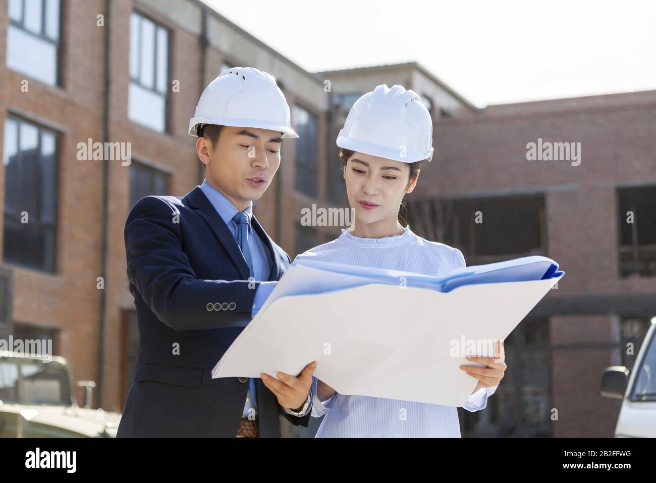 Two architects talking over blueprints Beijing China Stock Photo - Alamy