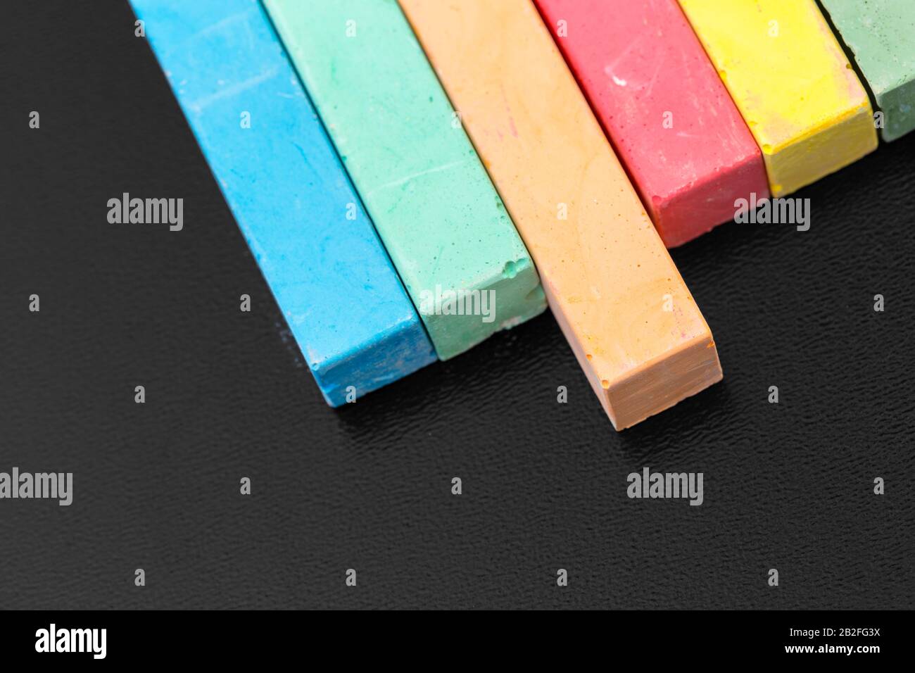 Set of colored chalks over a black background Stock Photo - Alamy