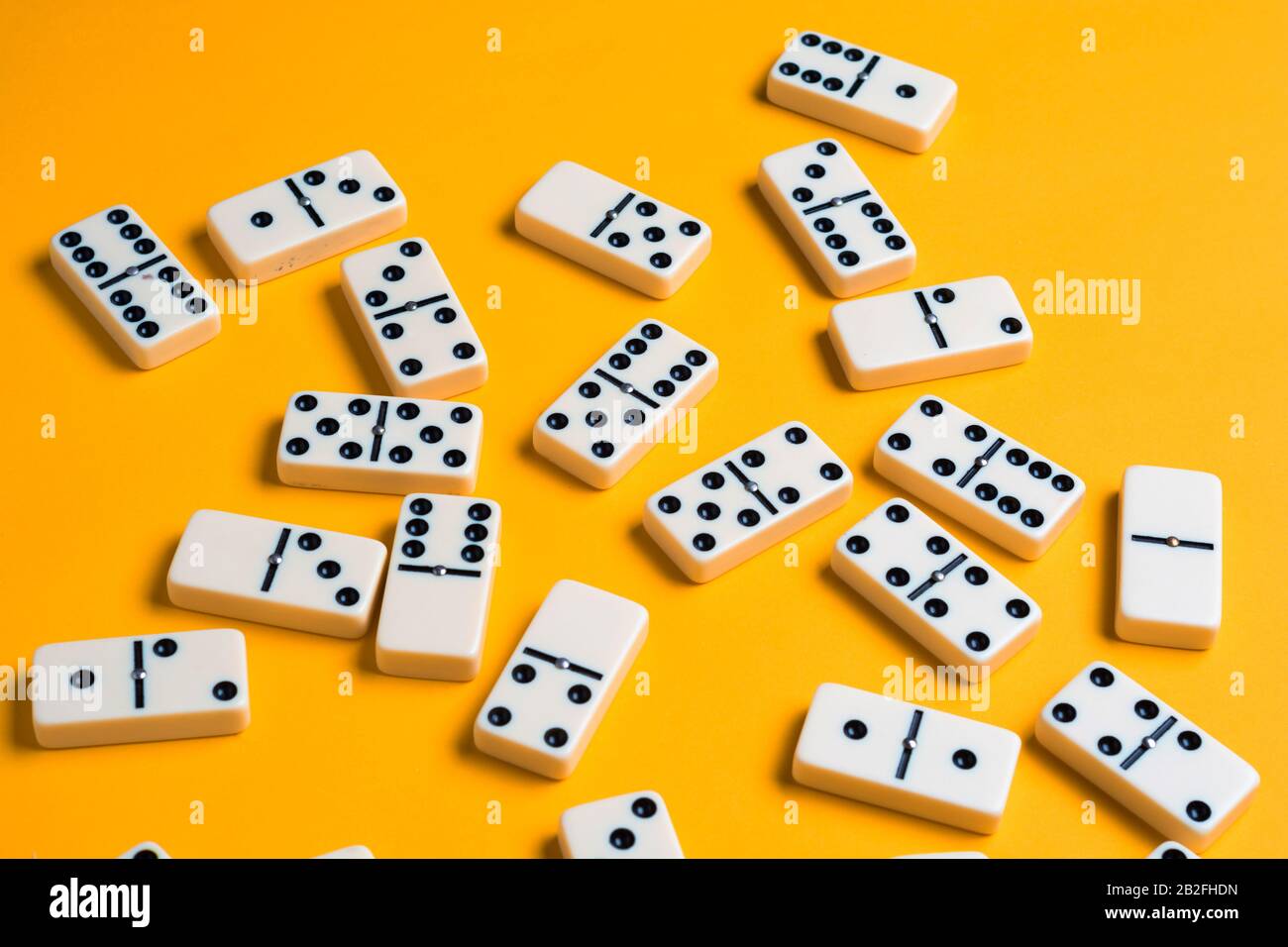 Playing dominoes on a orange table. Domino effect Stock Photo - Alamy