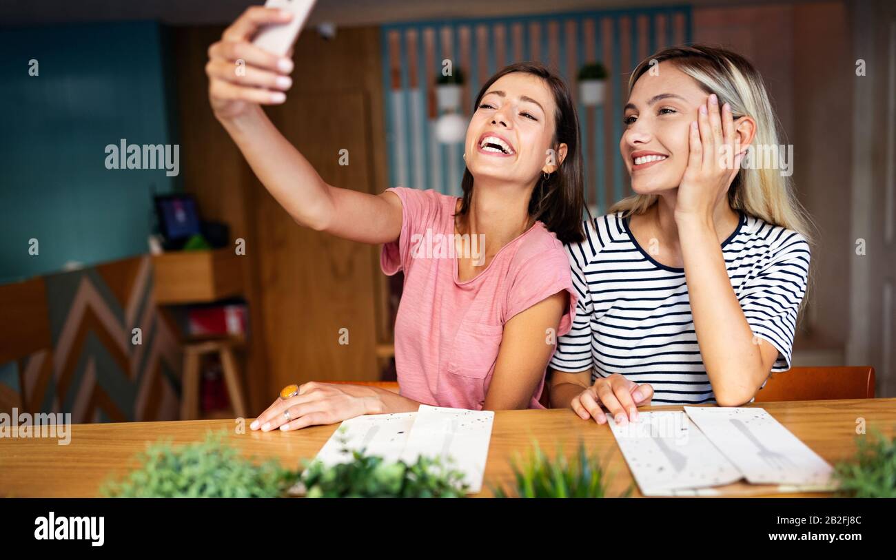 Happy smiling women friends having fun and taking selfie Stock Photo ...