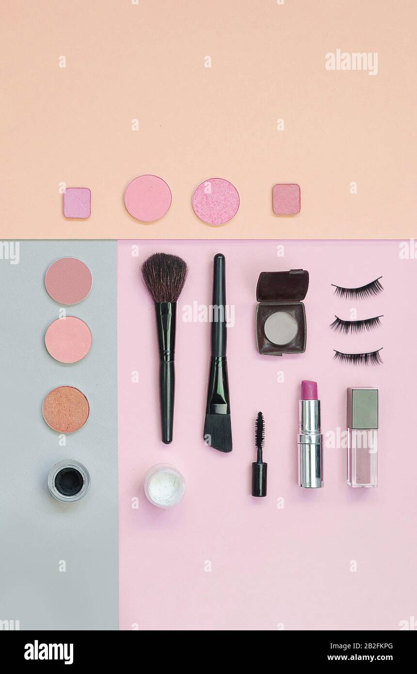 Colorful cosmetics lying on pink and yellow background. Makeup set ...