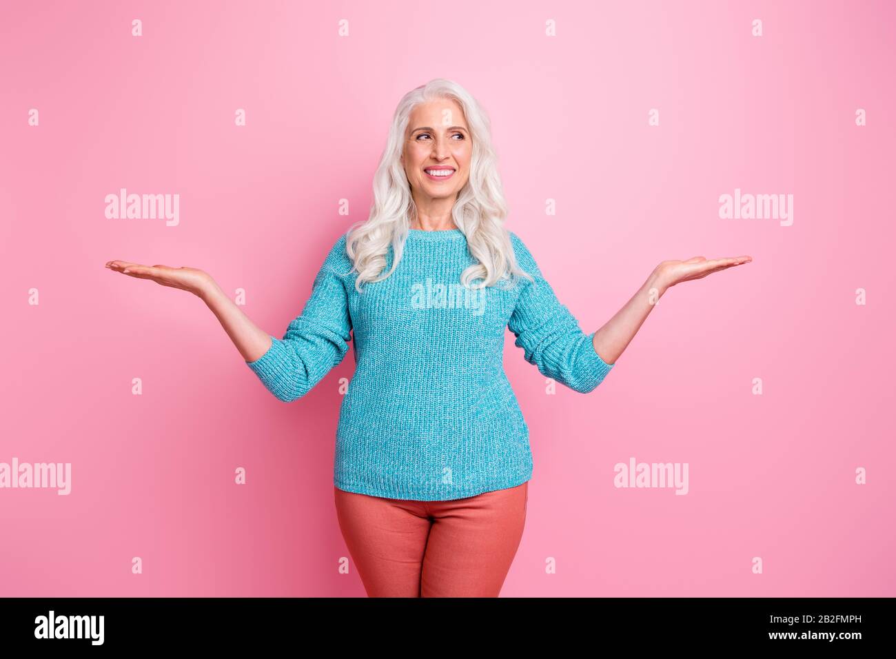 Portrait of positive cheerful old woman hold hand compare ads promotion ...