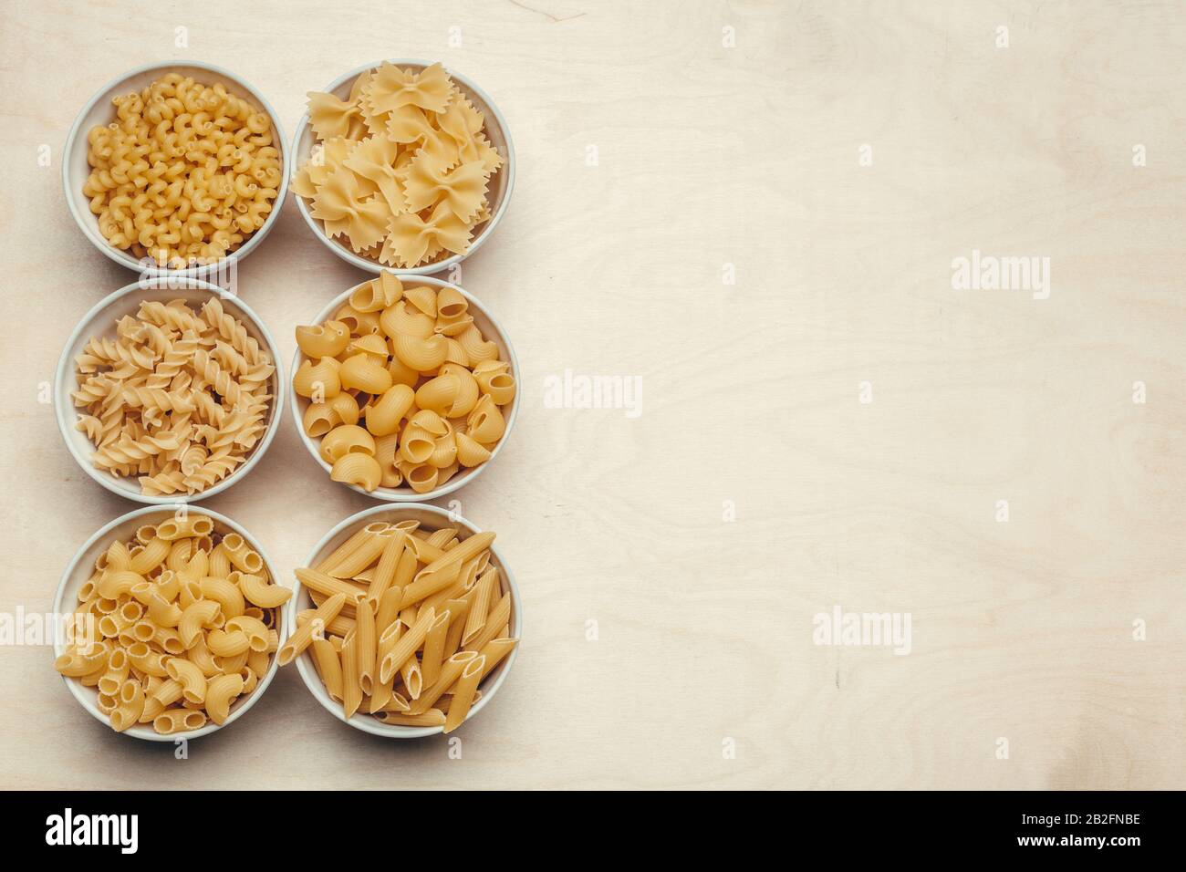 Different pasta types in bowls on the table Stock Photo - Alamy