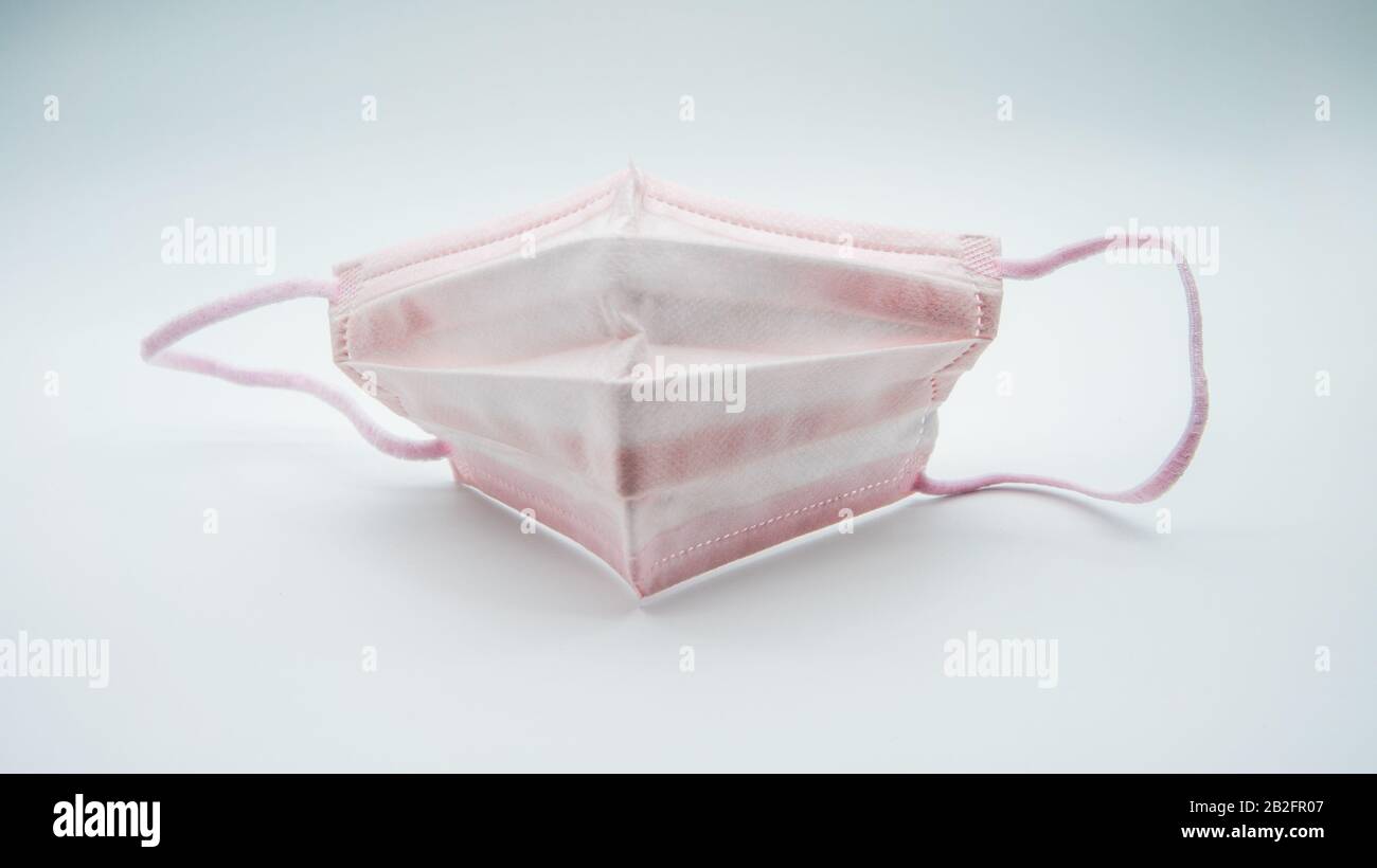 Close-up of medical mask pink on a white background. A disposable masks ...