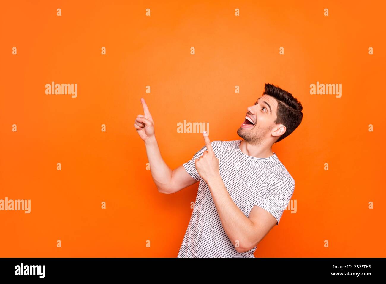 Photo of attractive funny crazy guy hold hands fingers direct up empty ...