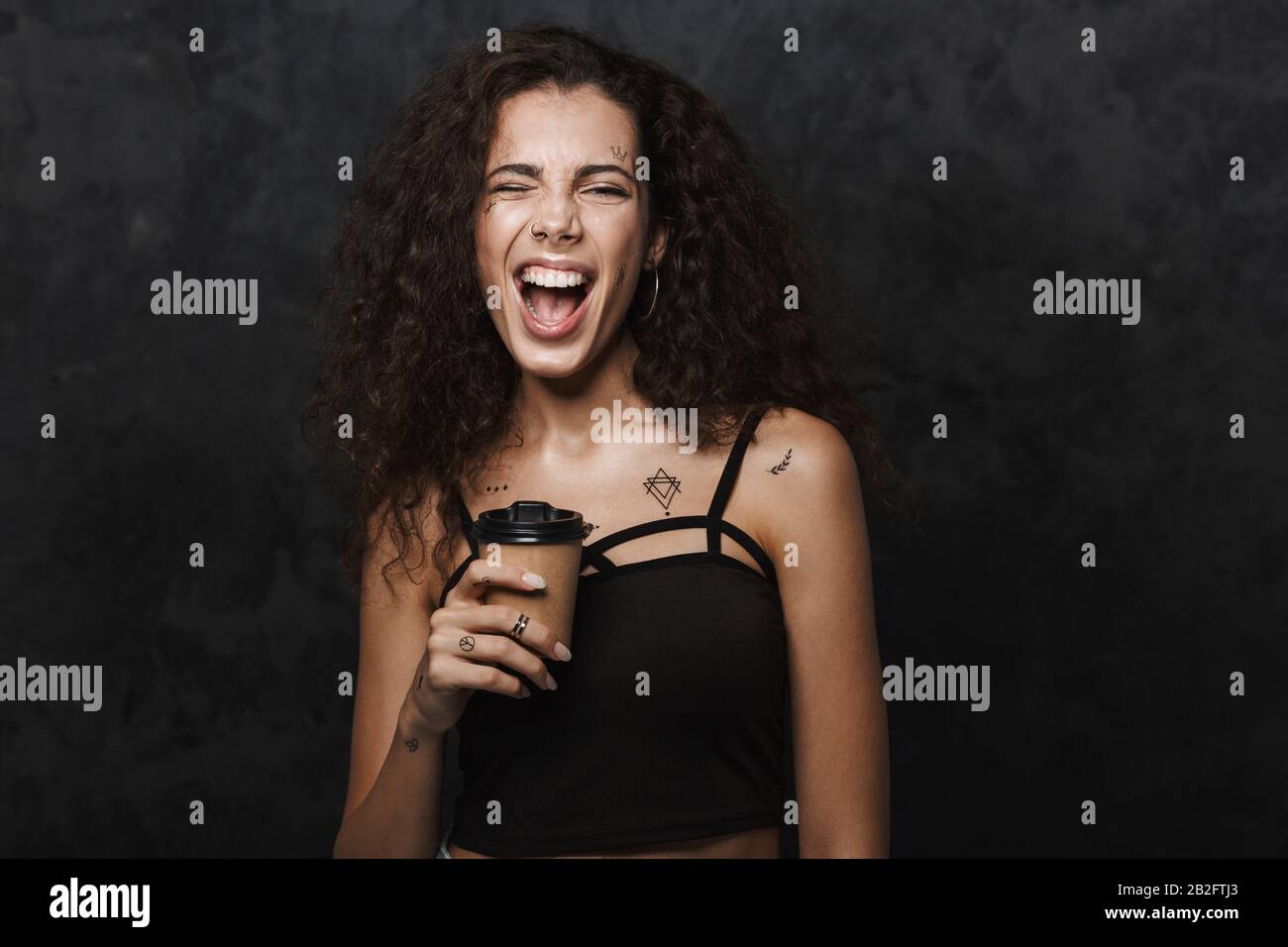 Image of nice cheerful woman with tattoo winking and drinking coffee ...