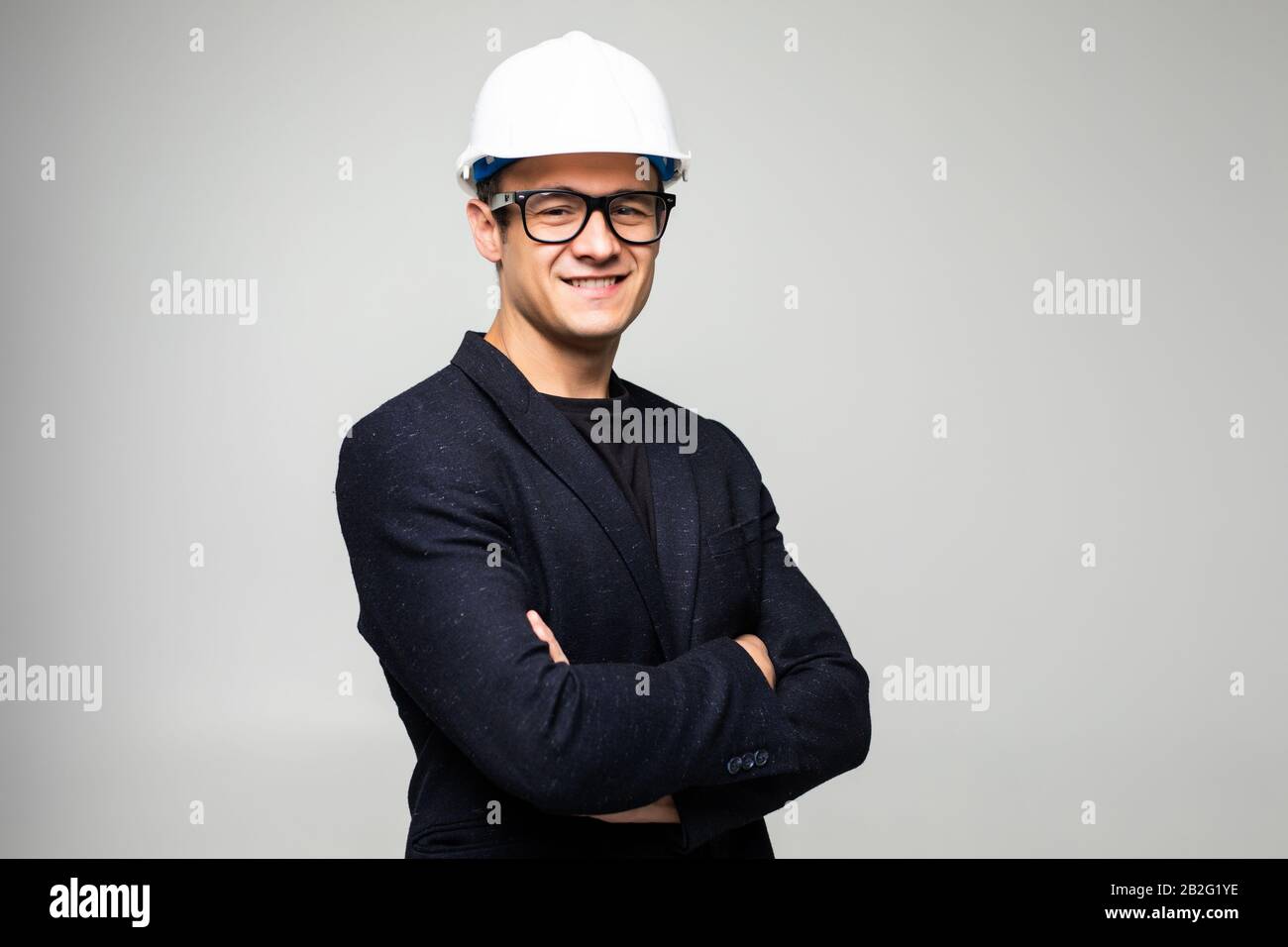 Confident man engineer wearing protective helmet holding hands crossed ...
