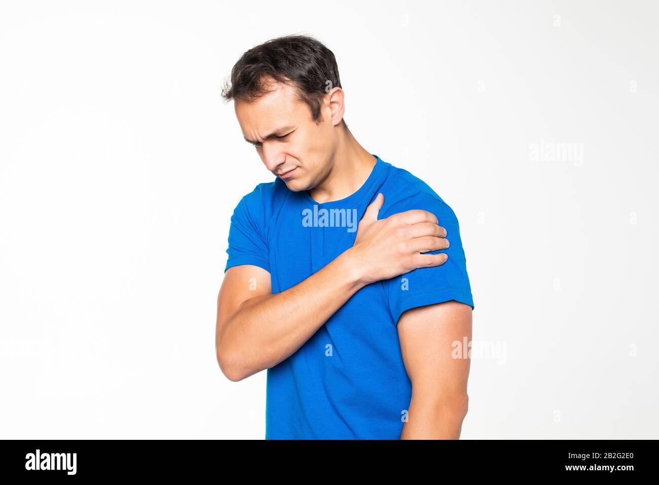 Young fitness man with ache in muscle after training isolated on white ...