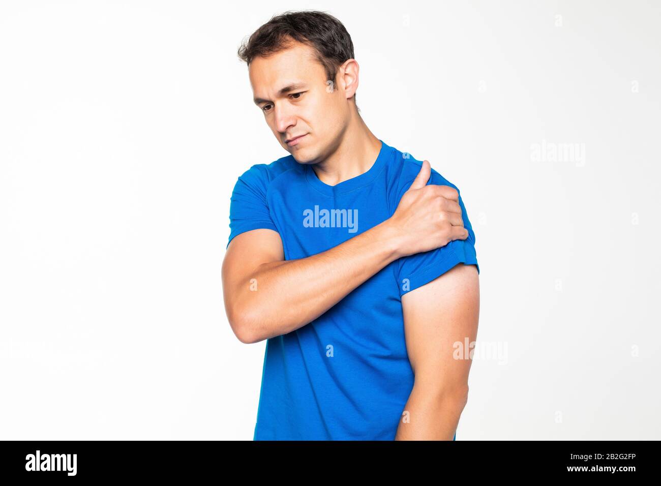 Young fitness man with ache in muscle after training isolated on white ...