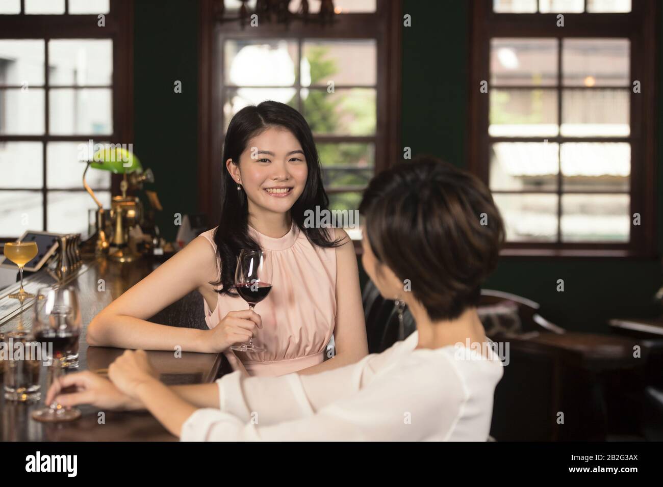 Two young women drinking red wine Stock Photo - Alamy
