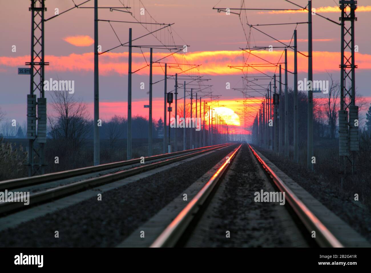 Railroad - Railway at sunset with sun Stock Photo - Alamy