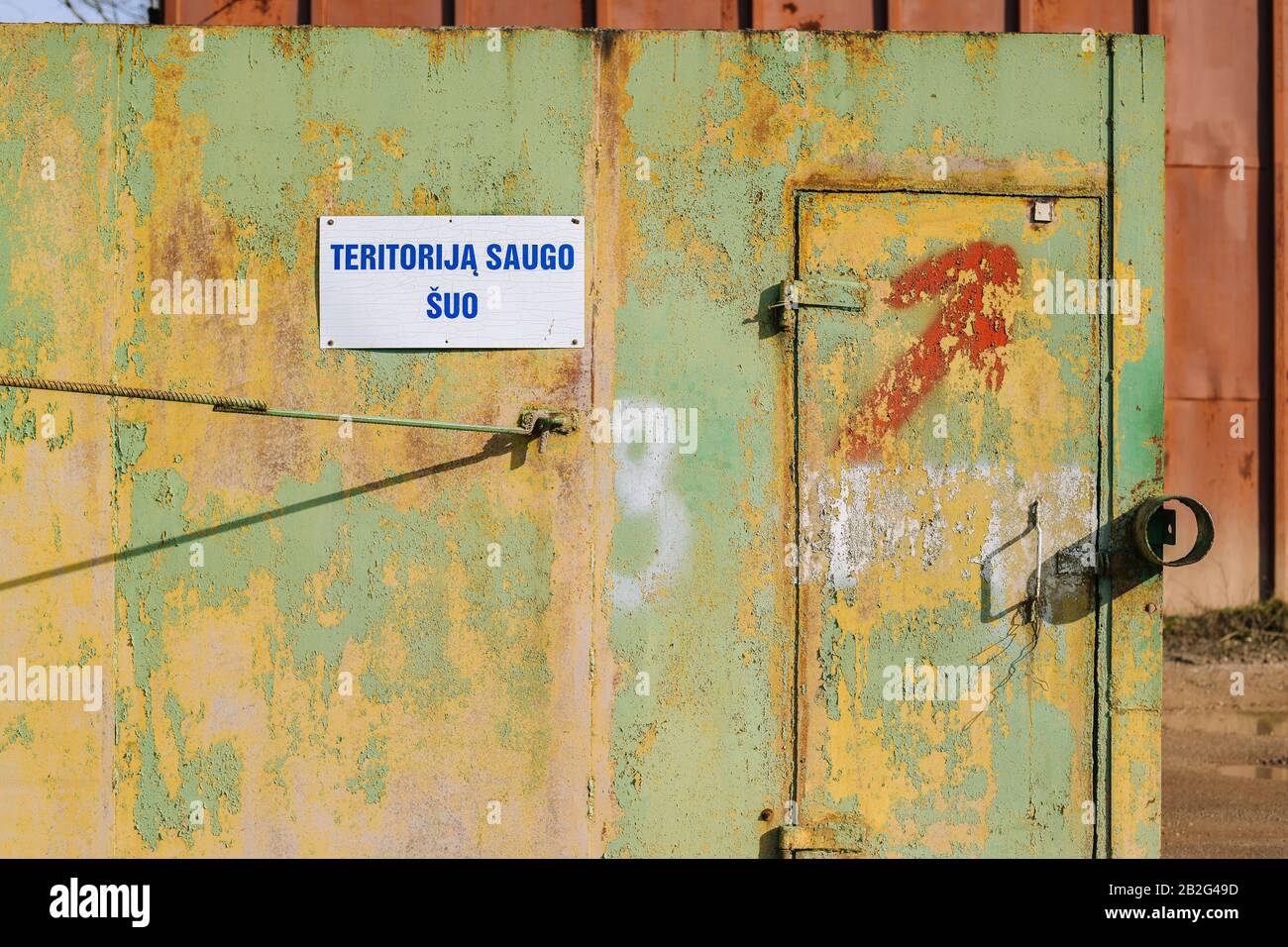 Rusty doors and sign that says "Dog protects the territory Stock Photo ...