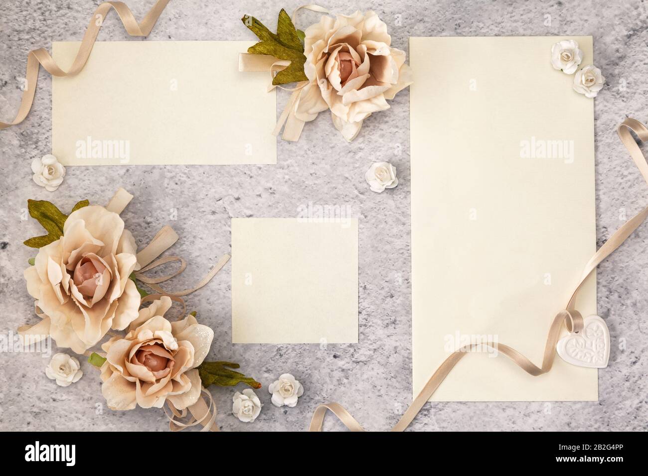 Wedding invitation cards papers laying on table decorated with roses ...