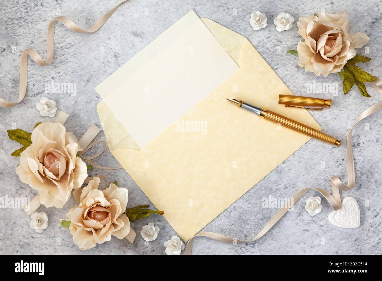 Wedding invitation cards papers laying on table decorated with roses ...