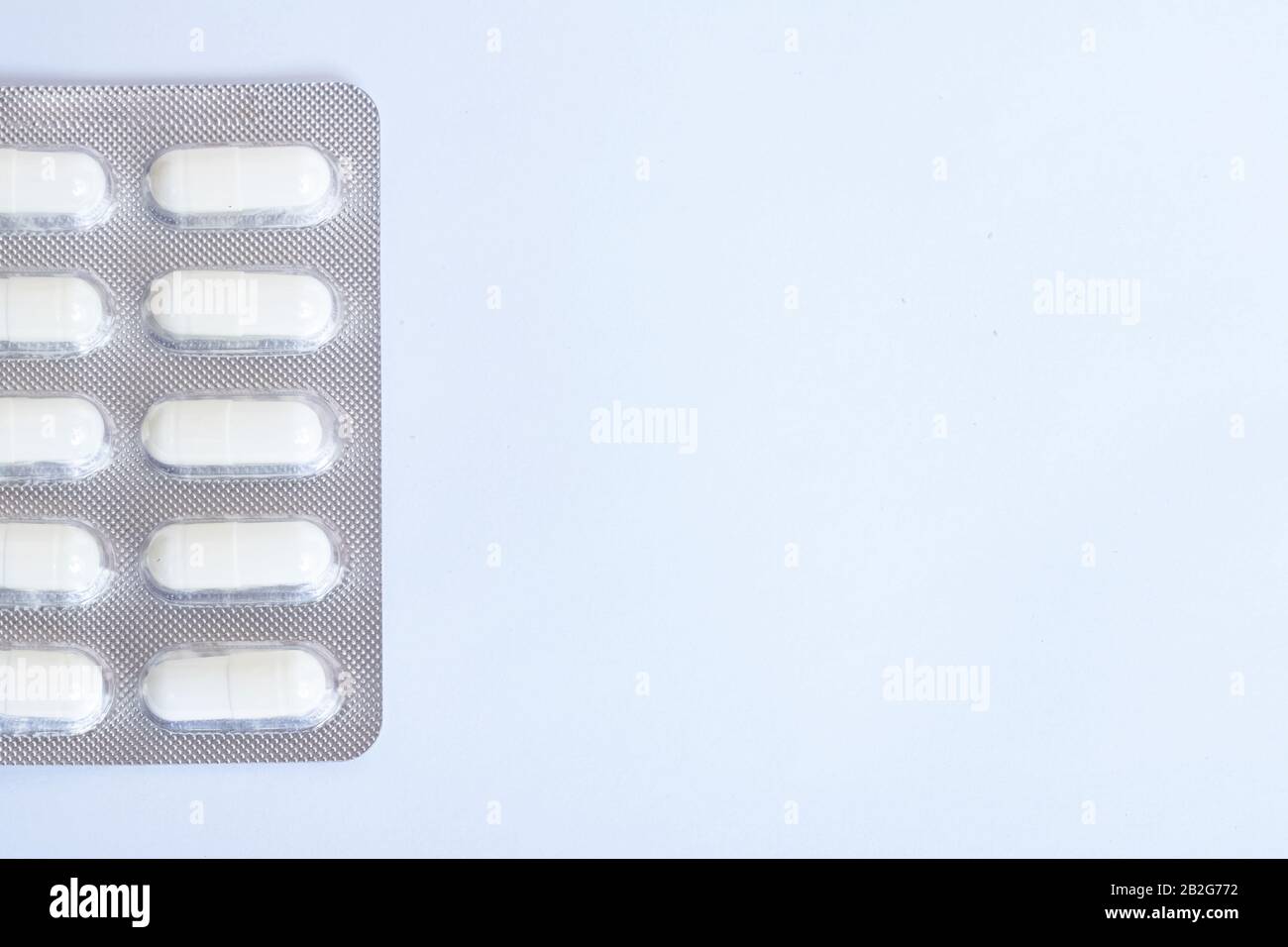 Packing of white tablets on blue background Stock Photo - Alamy