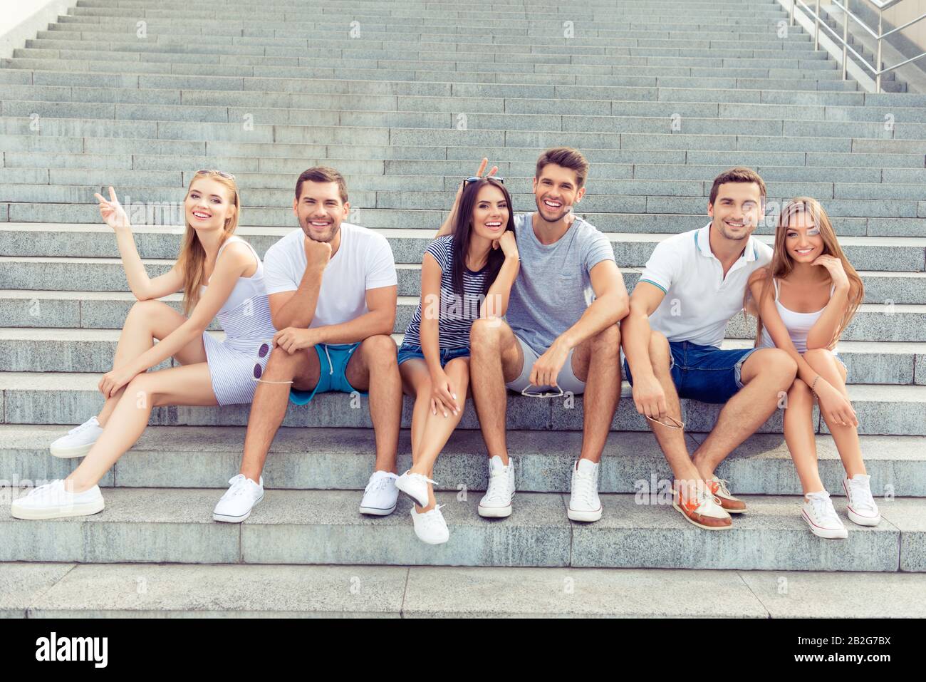 Happy cheerful best friends sitting on stairs and having fun Stock ...