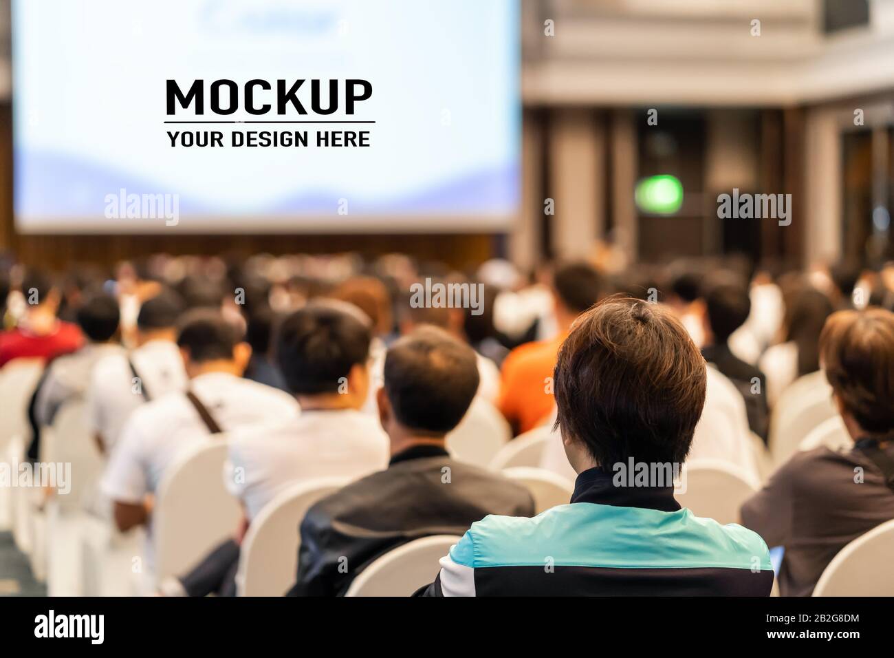 Rear view of Audience listening Speakers on the stage with presentation ...