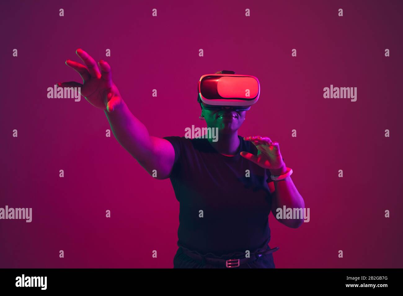 Pointing, touching. African-american young woman's portrait on purple ...