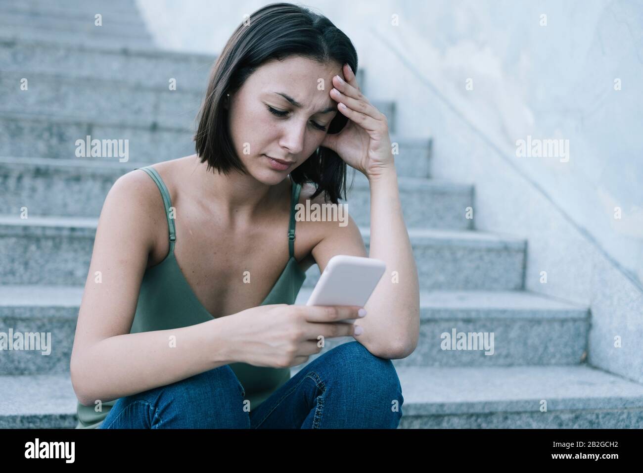 Sad woman checking smart phone online content in the city Stock Photo ...