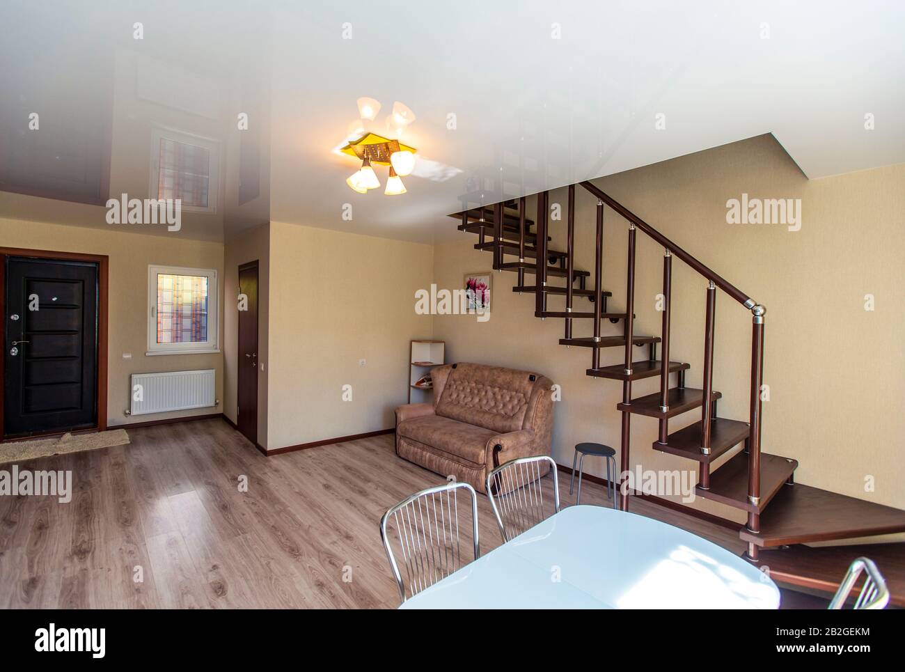 A dark wood wooden staircase with a shiny round Nickel-plated railing ...