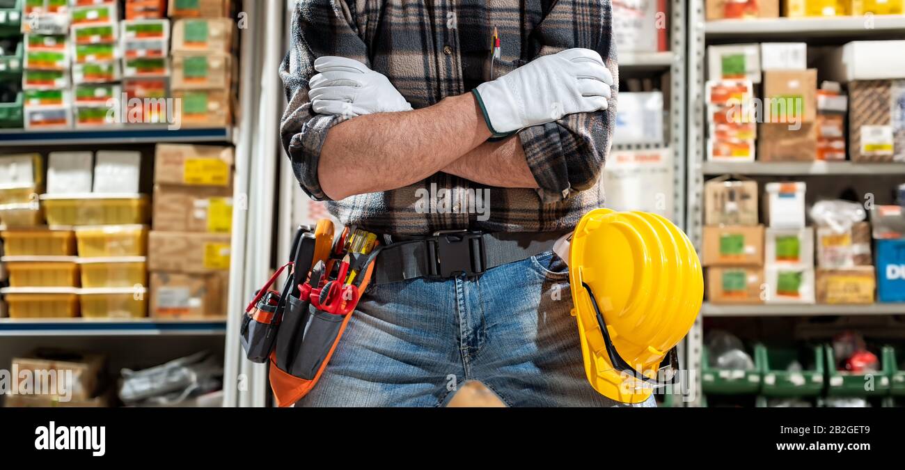 Carpenter electrician in the store of electrical components with arms ...
