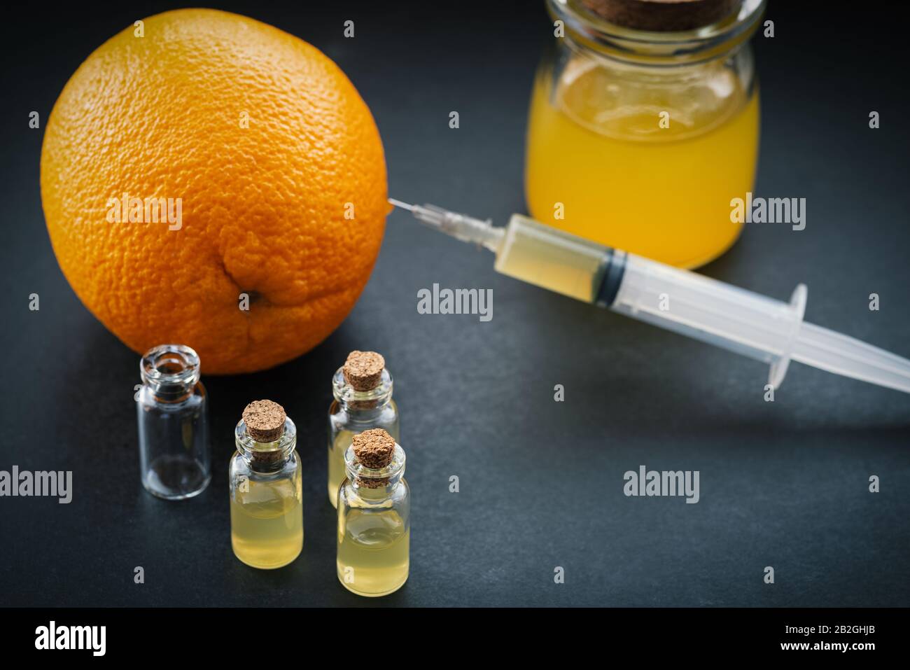 Orange with syringe injection colored liquid Stock Photo - Alamy