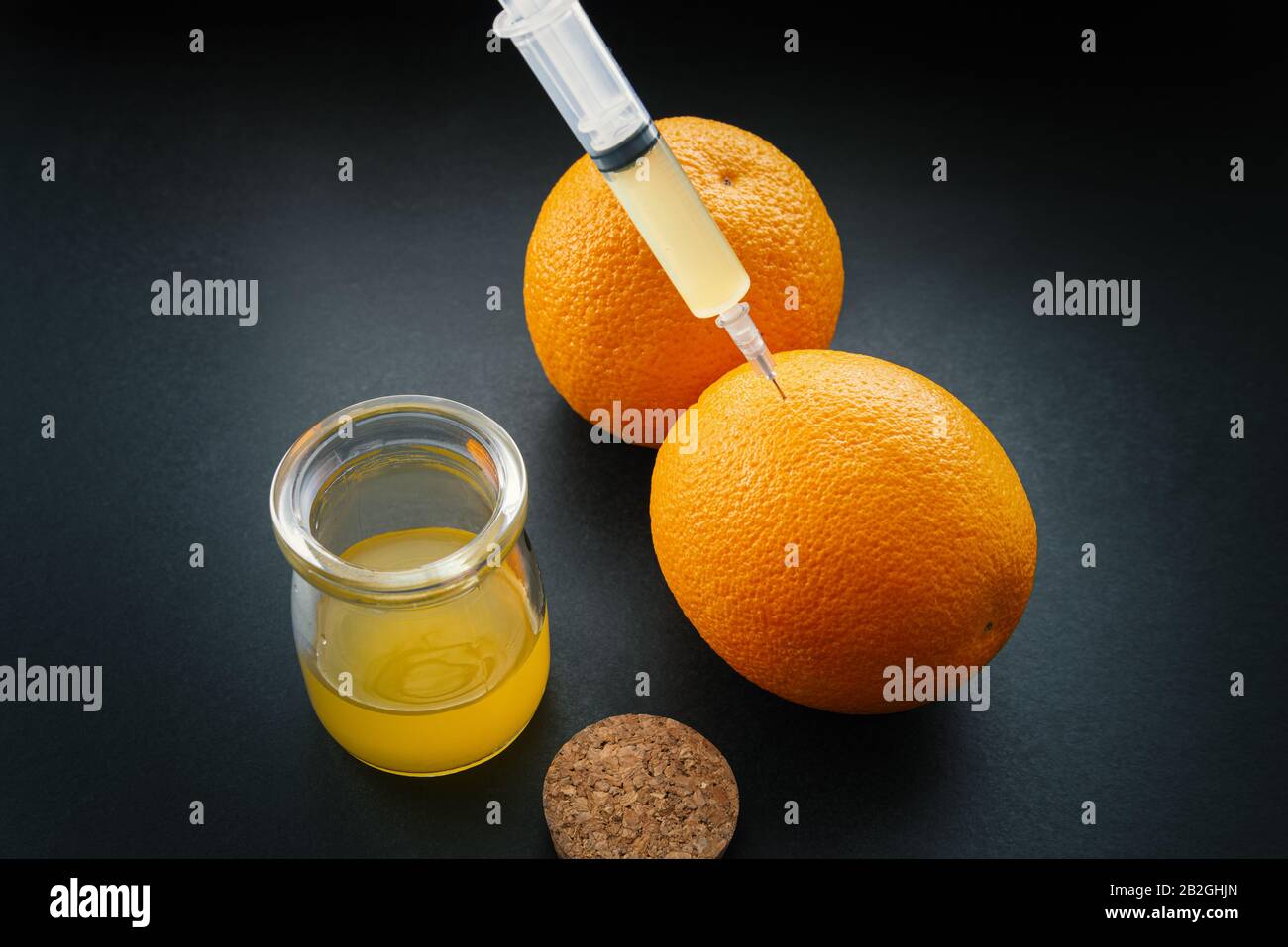 Orange with syringe injection colored liquid Stock Photo - Alamy