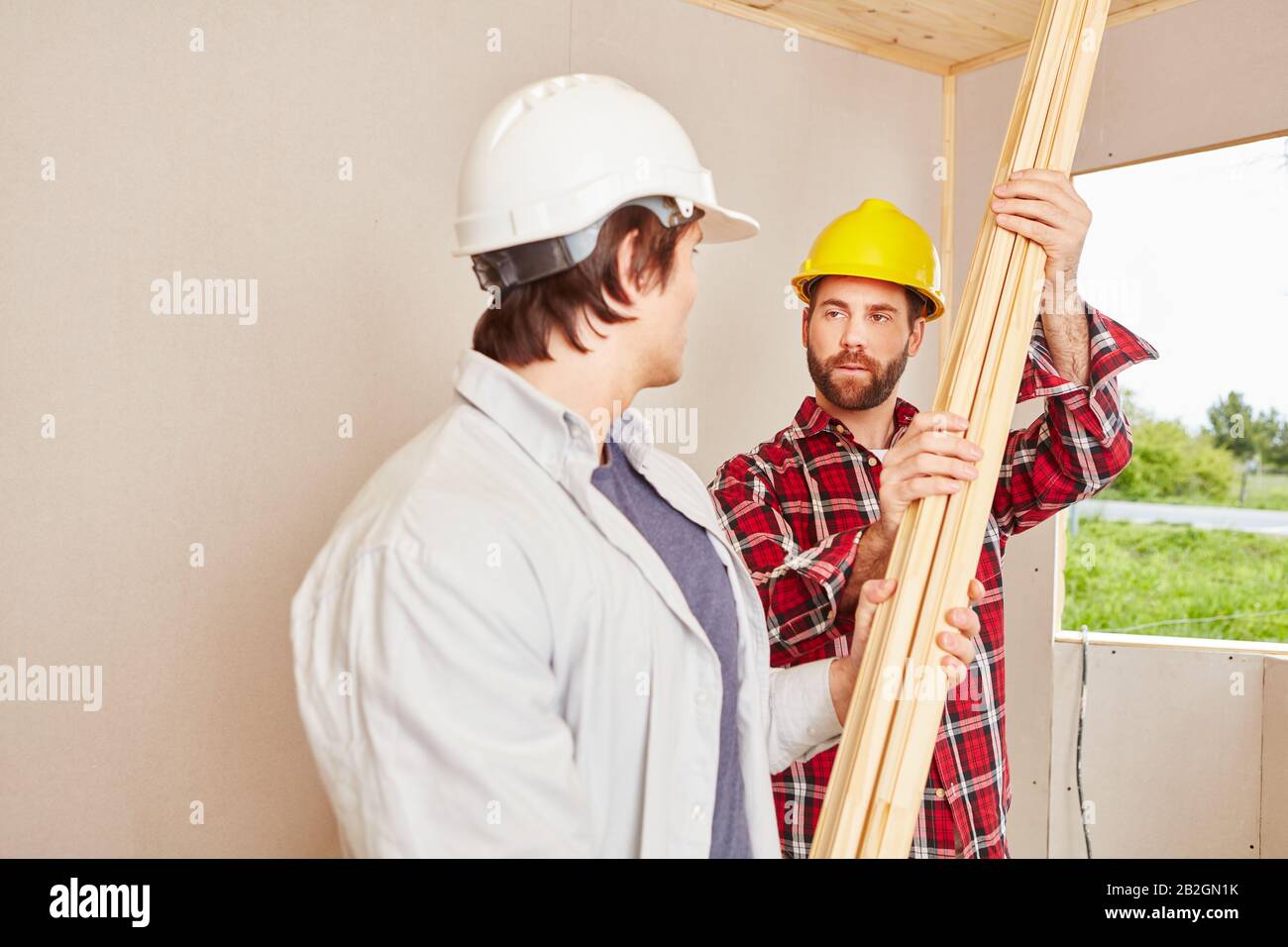 Two craftsmen build a house together with wood Stock Photo - Alamy