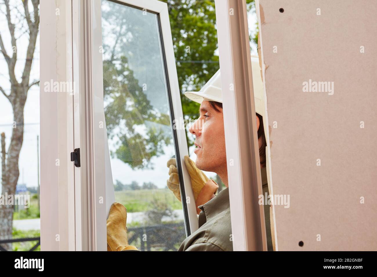 Window fitter installs a window on a construction site Stock Photo - Alamy