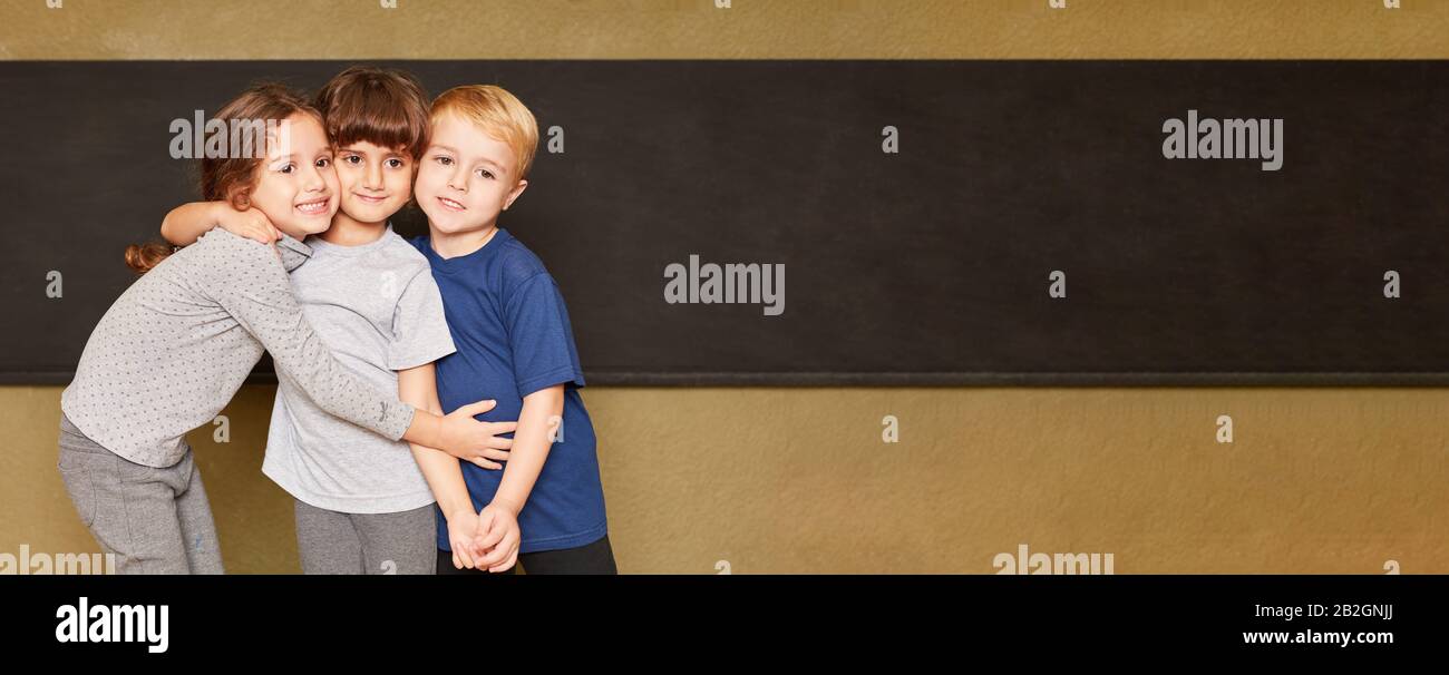 Group of kids as friends in kindergarten hugs each other as a header ...