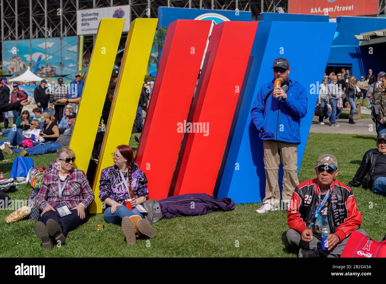 Fans stand by a NASCAR logo signage during the NASCAR Auto Club 400 ...